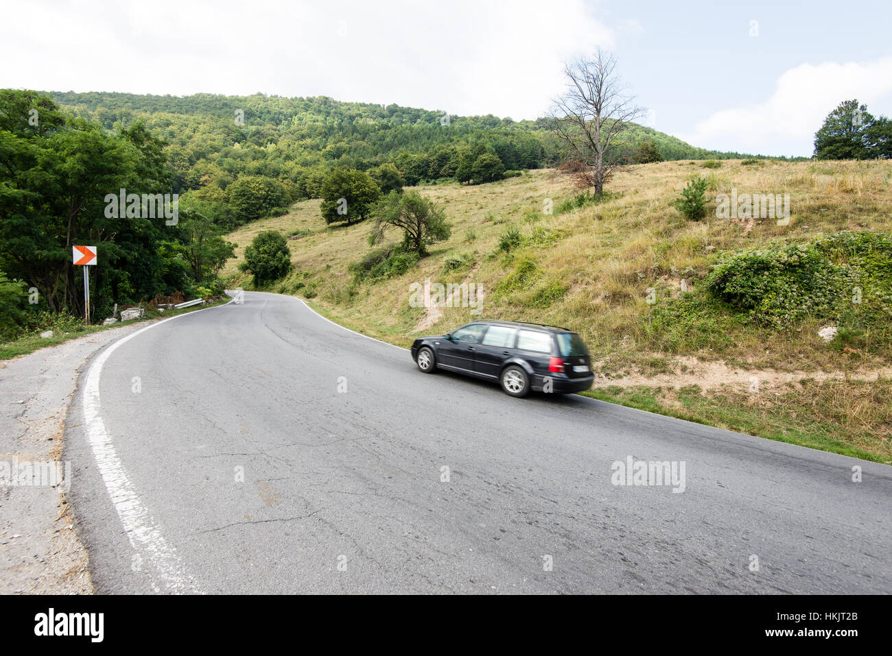 Winding country Road with clouds above and dry tarmac Stock Photo - Alamy