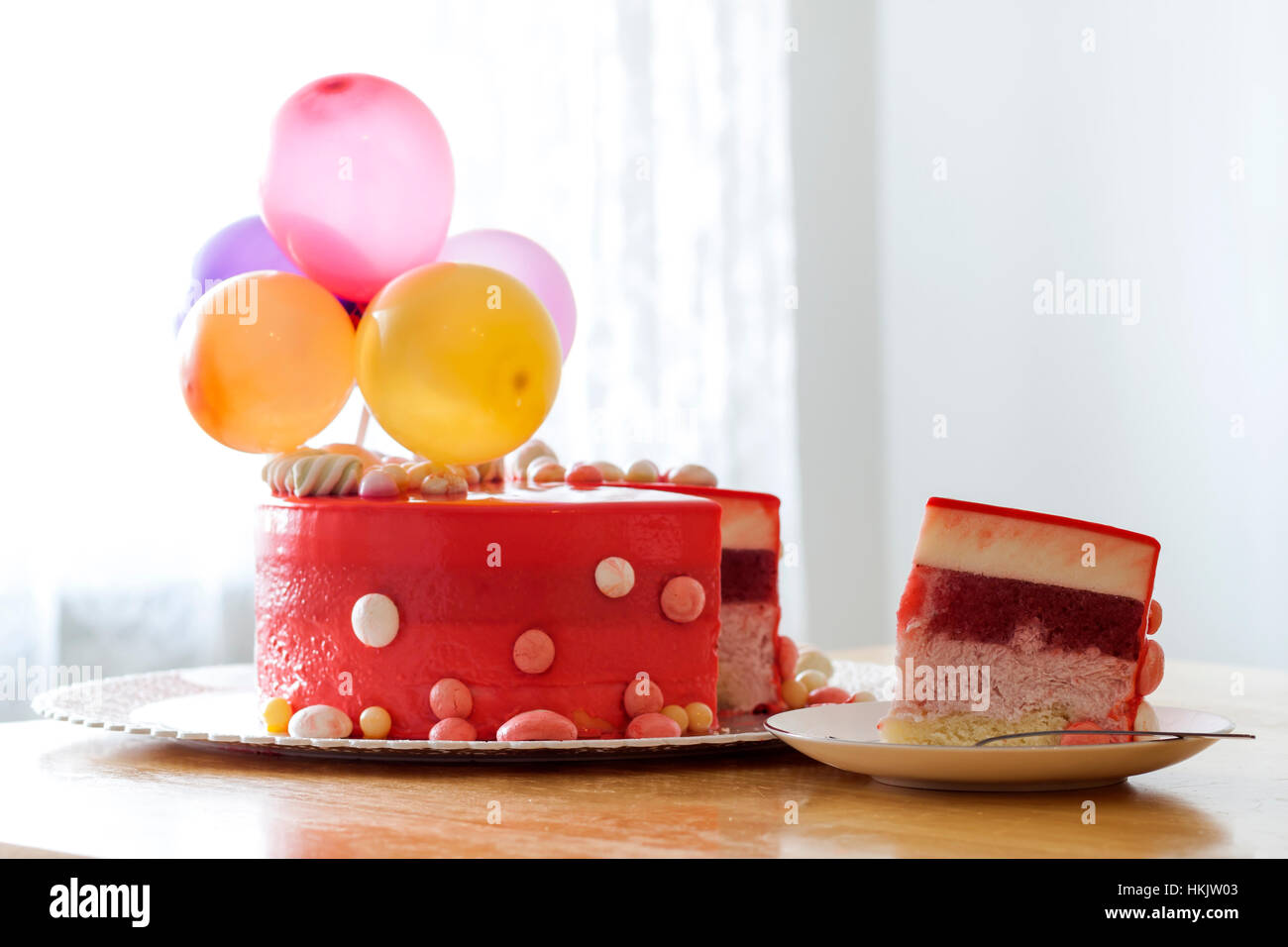 Homemade red birthday cake with air baloons. Slice of a red velvet cake ...