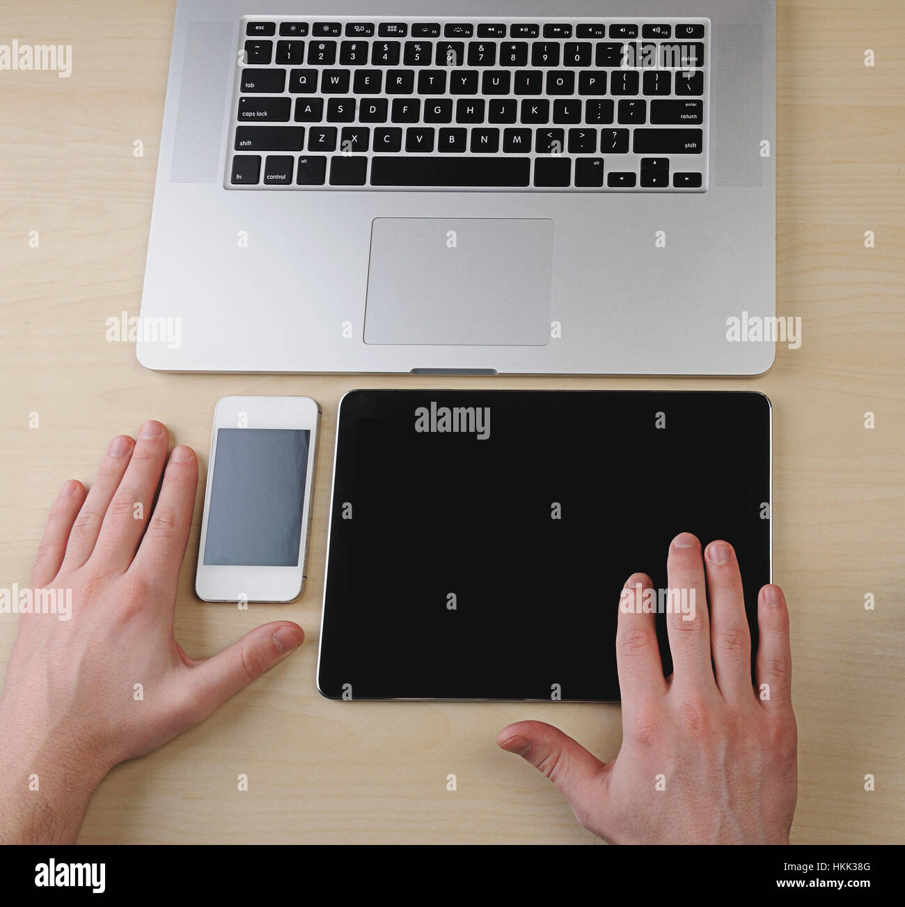 tablet, phone, laptop with hands on wooden table Stock Photo - Alamy