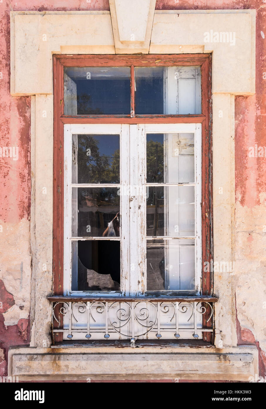 Worn out window frame in Portugal. With broken glass and peeling paint ...