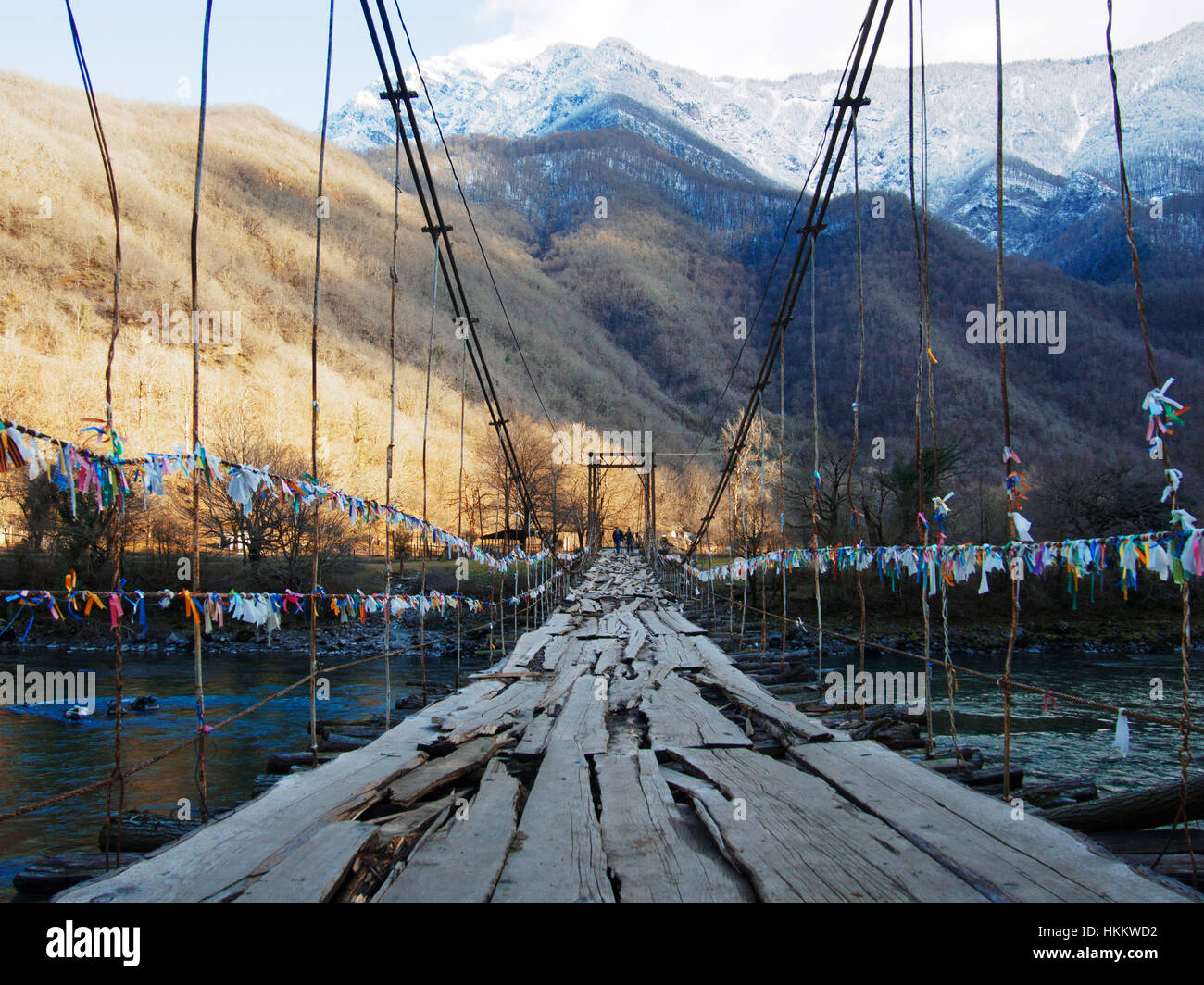 Old wooden bridge hanging over a gorge and mountain stream. Beautiful ...