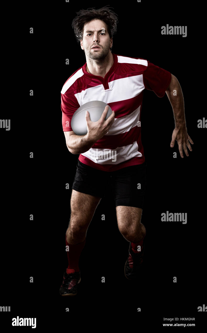 Rugby player in a red uniform running. Black Background Stock Photo - Alamy