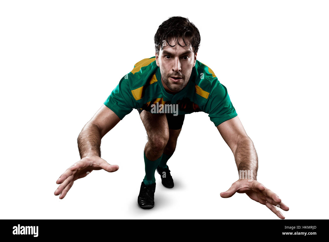 Rugby player in a green and gold uniform giving a tackle. White ...