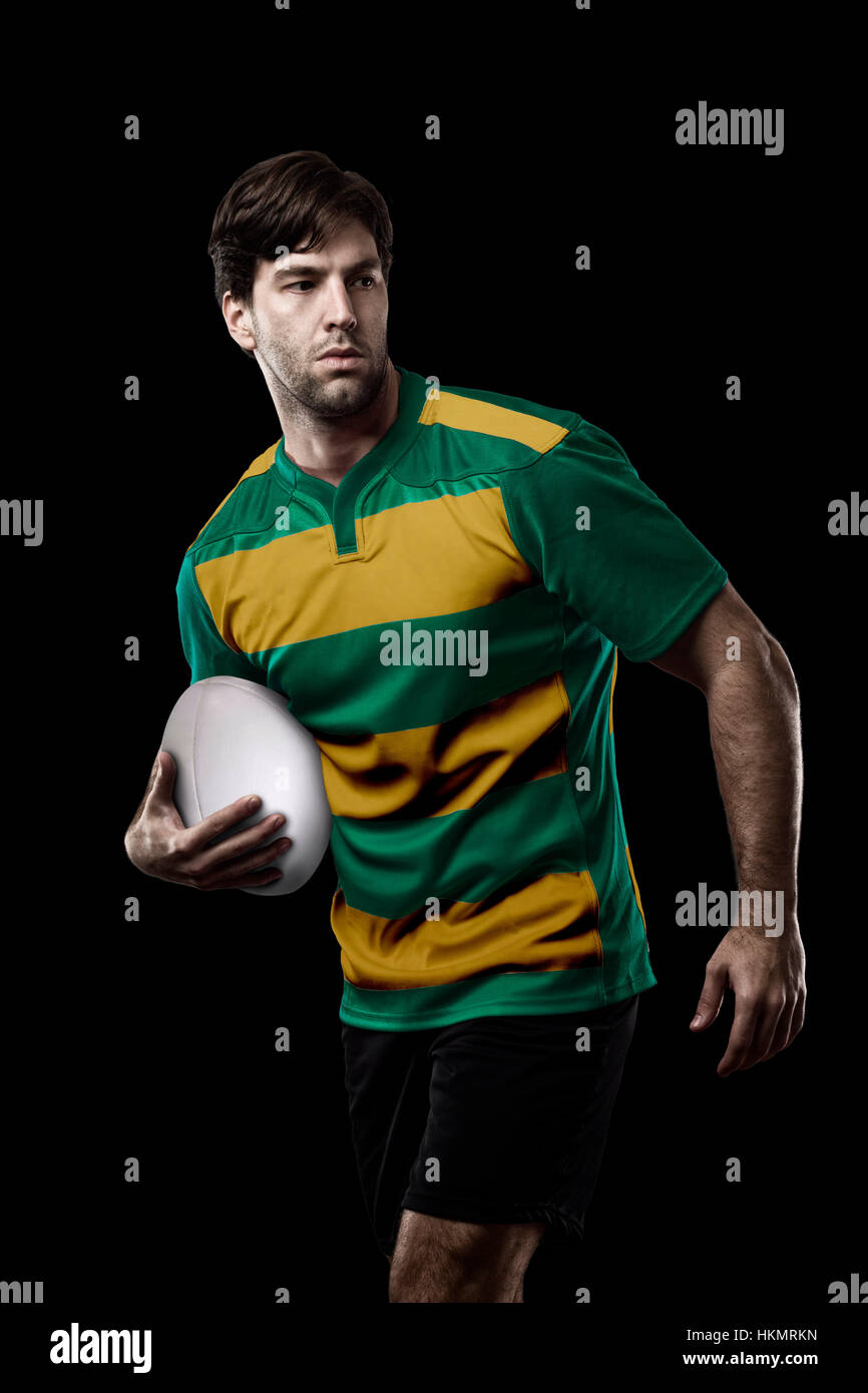 Rugby player in a green and gold uniform. black Background Stock Photo ...