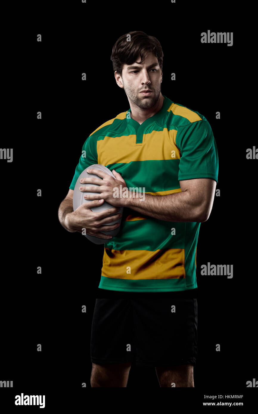 Rugby player in a green and gold uniform. black Background Stock Photo ...