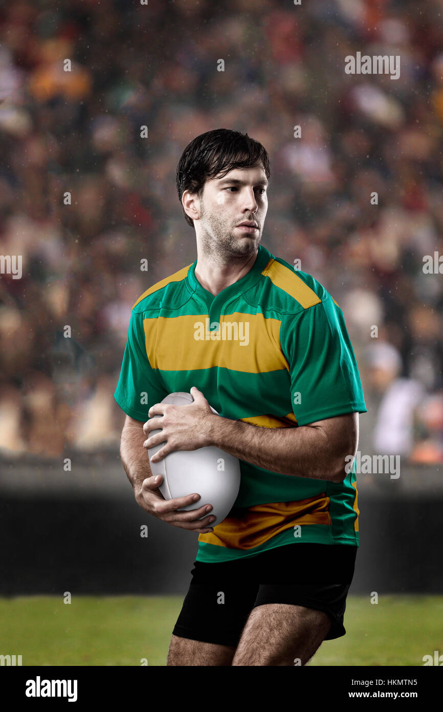 Rugby player in a green and gold uniform on a stadium Stock Photo - Alamy