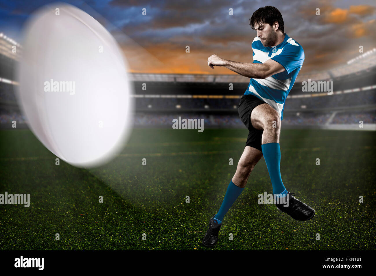Rugby player in a blue uniform kicking a rugby ball in a stadium Stock ...