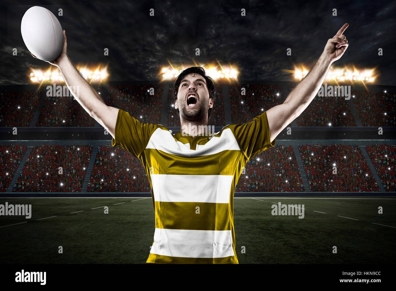Rugby player in a yellow uniform celebrating on a stadium Stock Photo ...