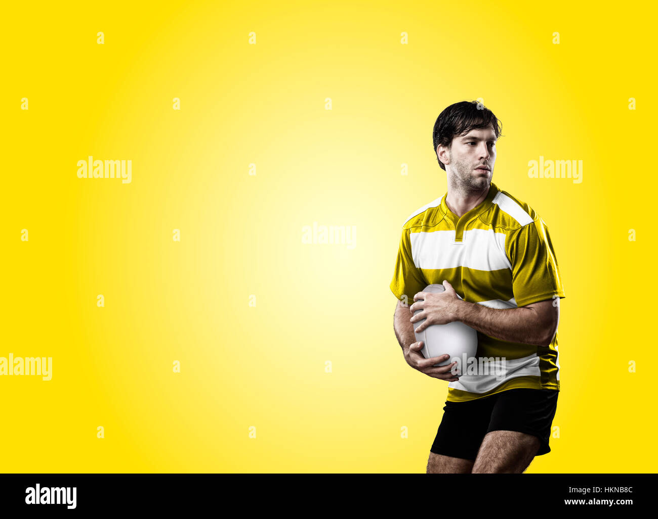 Rugby player in a yellow uniform on a yellow background Stock Photo - Alamy