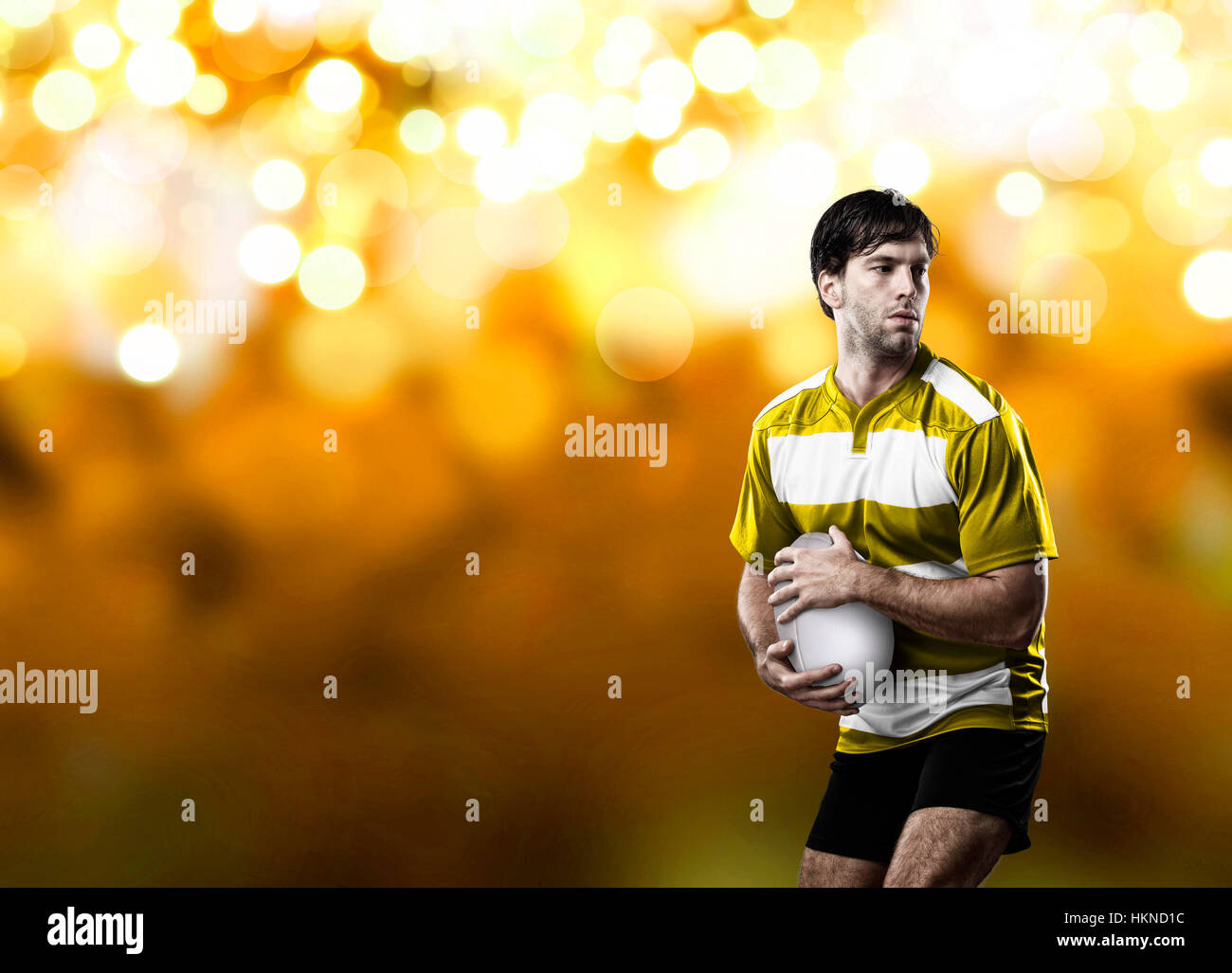 Rugby player in a yellow uniform on a yellow lights background Stock ...