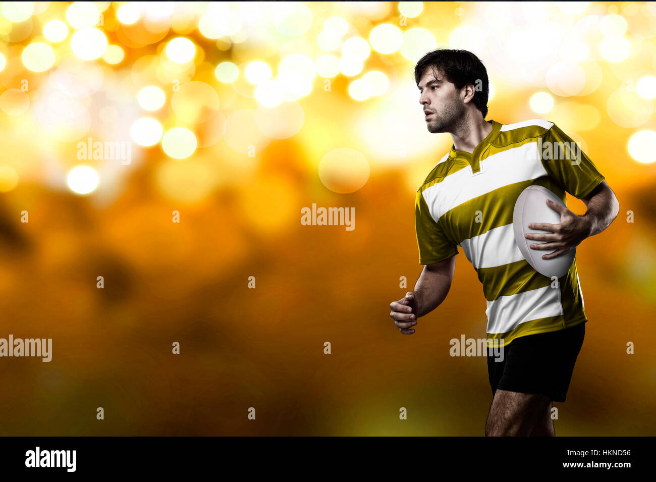 Rugby player in a yellow uniform on a yellow lights background Stock ...