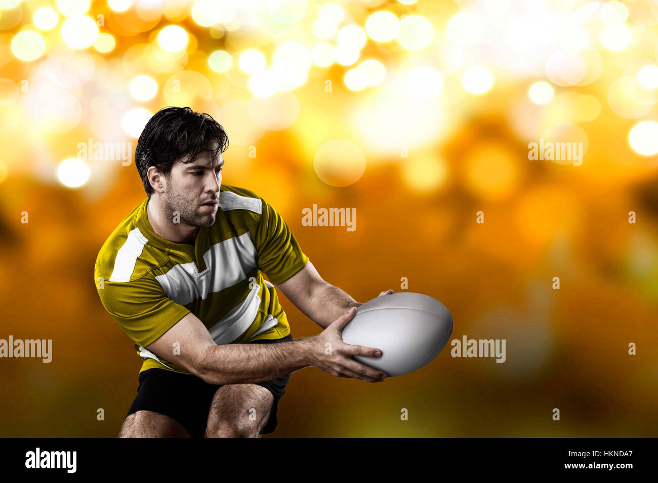 Rugby player in a yellow uniform on a yellow lights background Stock ...