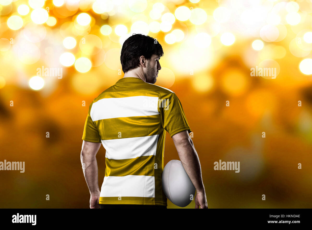 Rugby player in a yellow uniform on a yellow lights background Stock ...