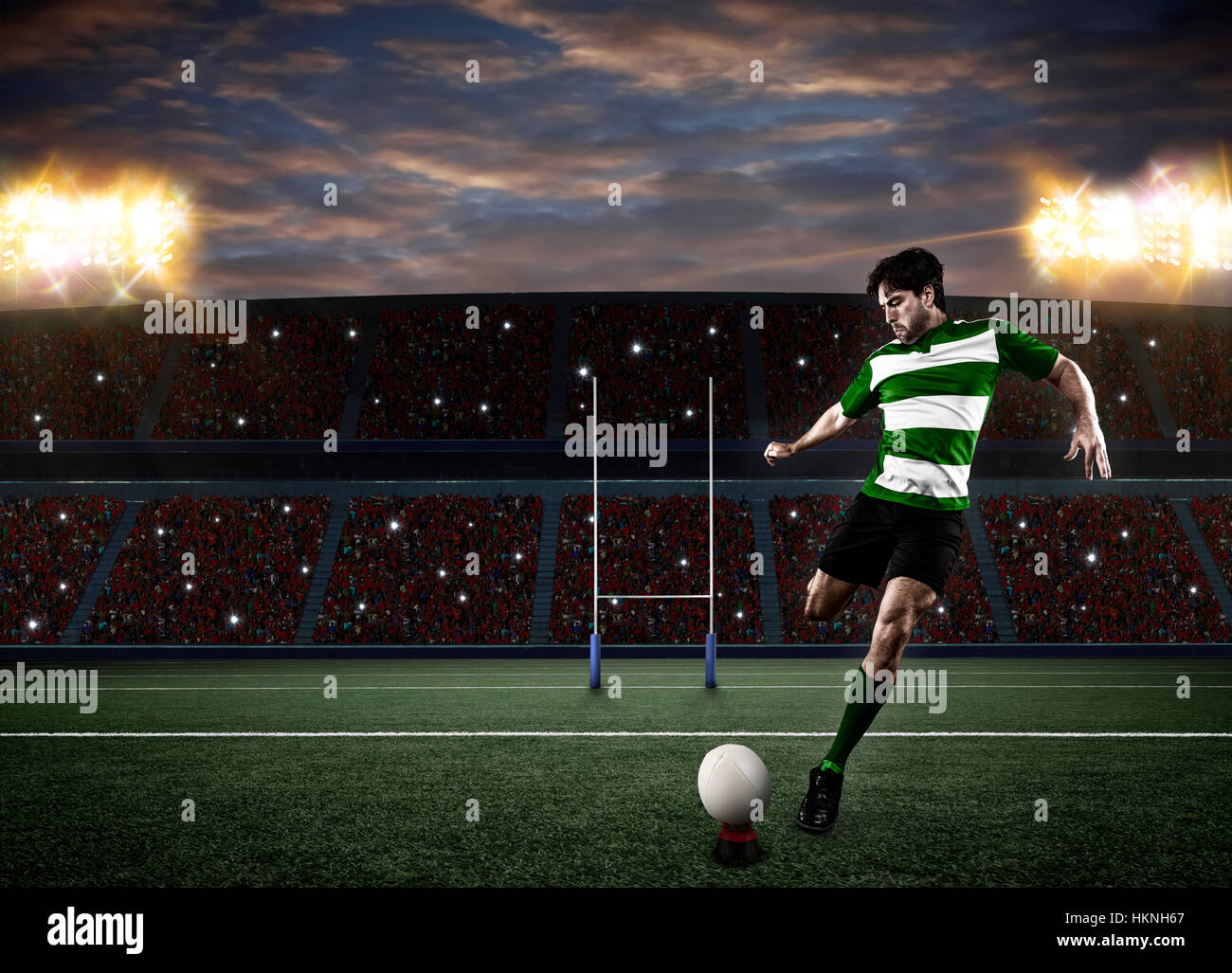 Rugby player in a green uniform kicking a ball on a stadium Stock Photo ...