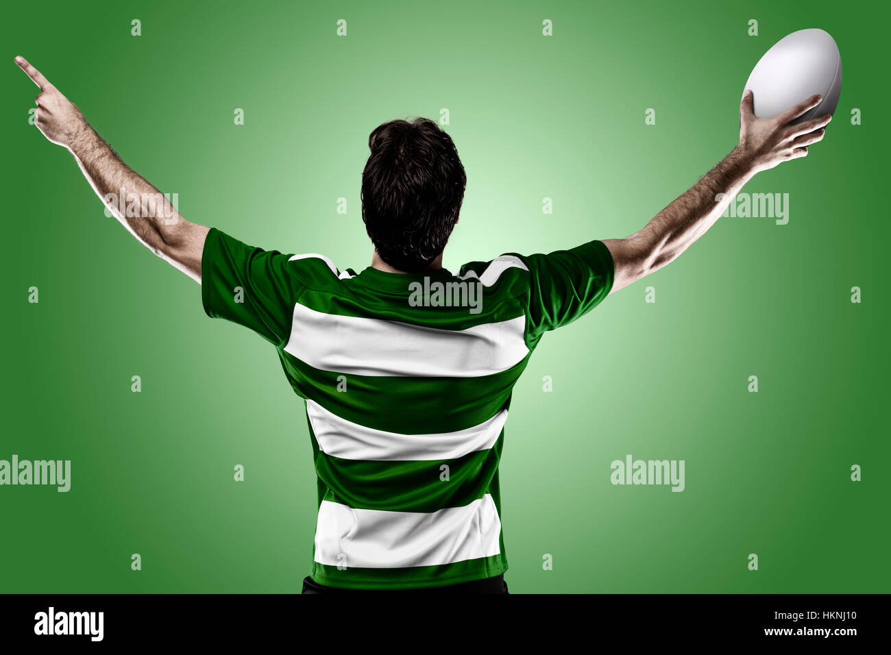 Rugby player in a green uniform celebrating on a green backgrond Stock ...