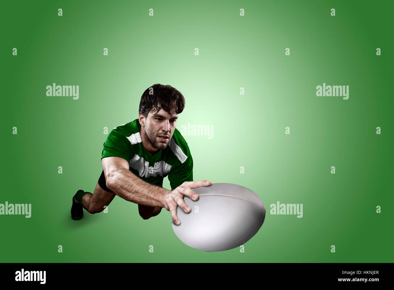 Rugby player in a green uniform scoring on a green backgrond Stock ...