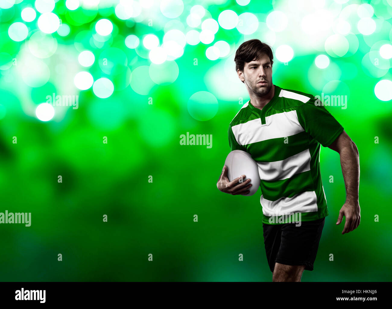 Rugby player in a green uniform on a green lights backgrond Stock Photo ...