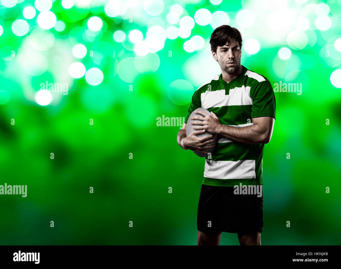 Rugby player in a green uniform on a green lights backgrond Stock Photo ...