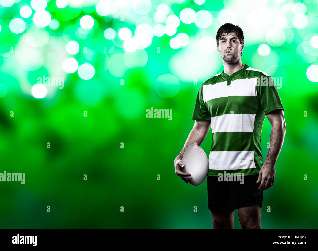 Rugby player in a green uniform on a green lights backgrond Stock Photo ...