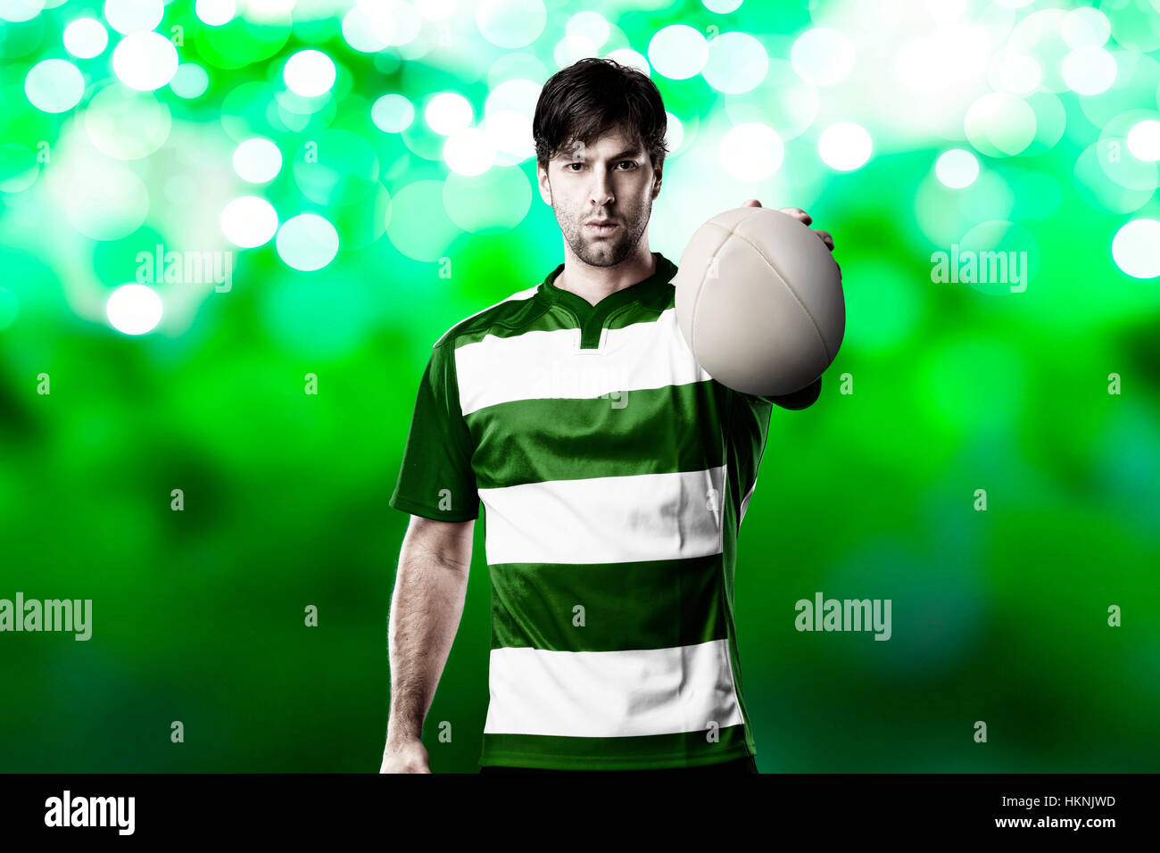 Rugby player in a green uniform on a green lights backgrond Stock Photo ...