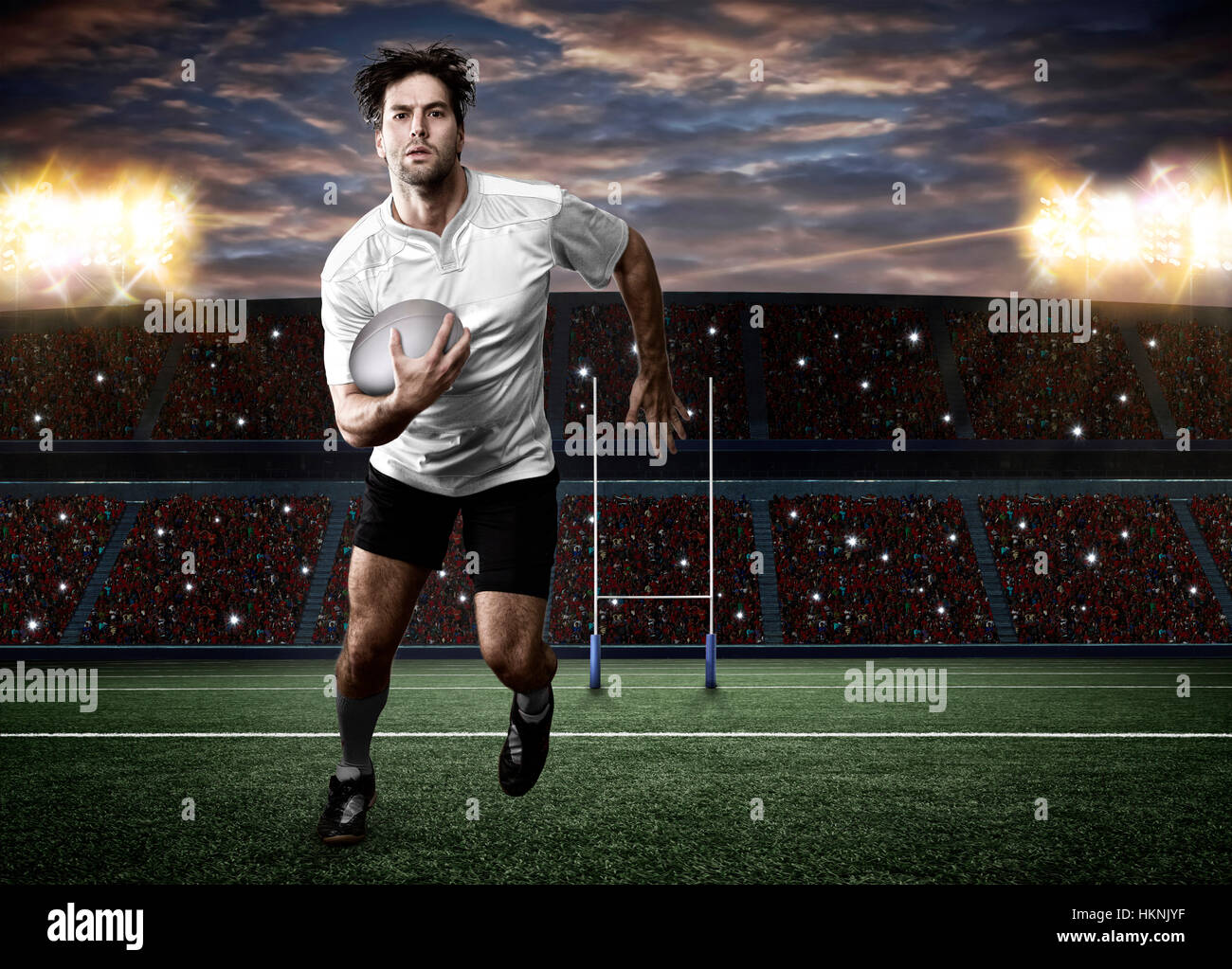 Rugby player in a white uniform running on a stadium Stock Photo - Alamy