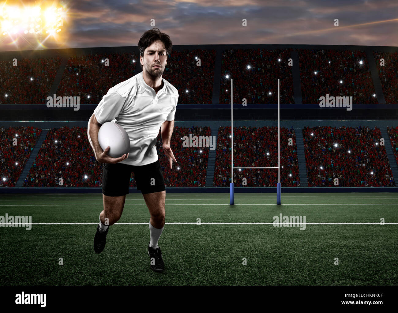 Rugby player in a white uniform running on a stadium Stock Photo - Alamy