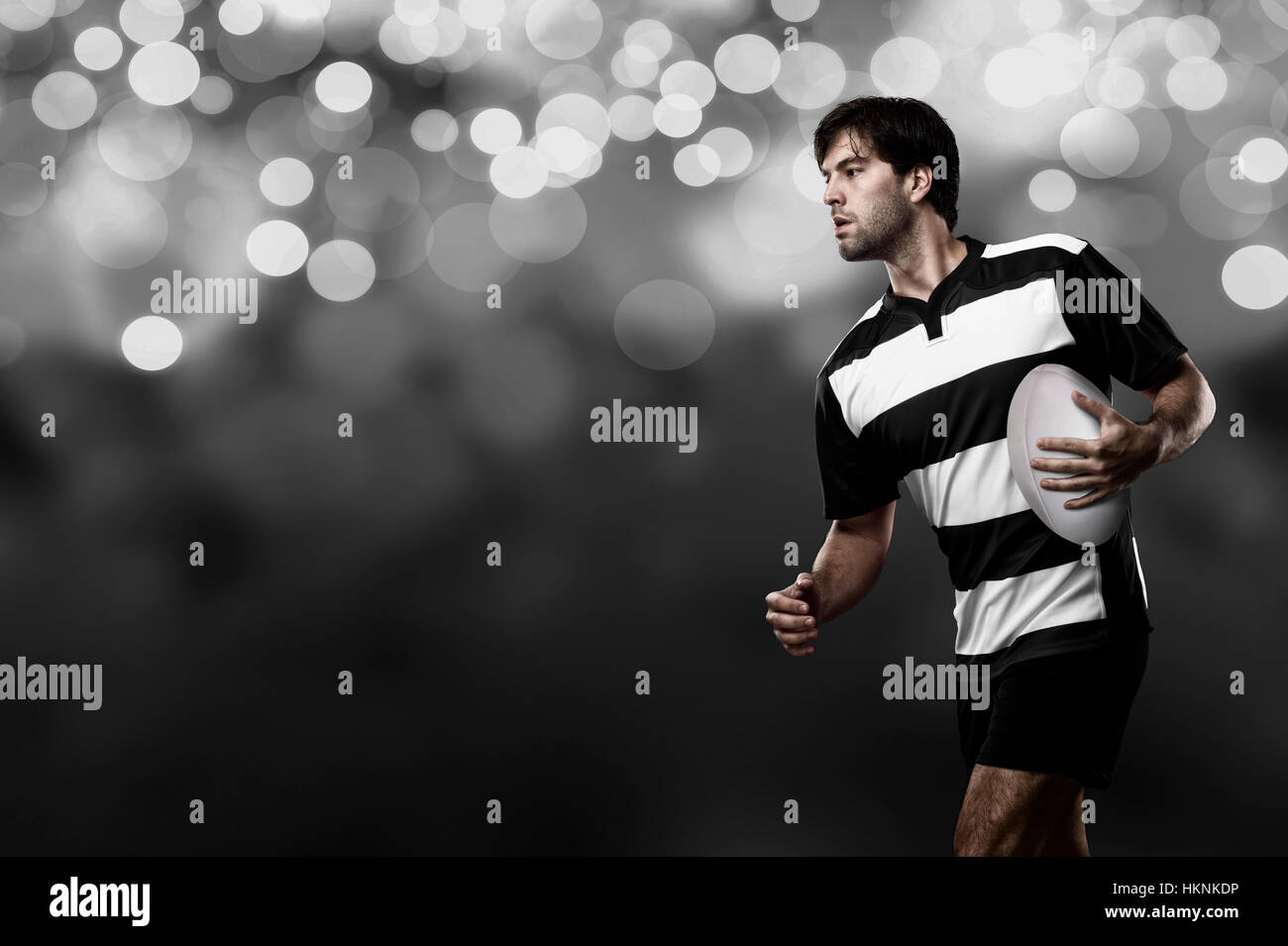Rugby player in a black uniform on a black lights background Stock ...