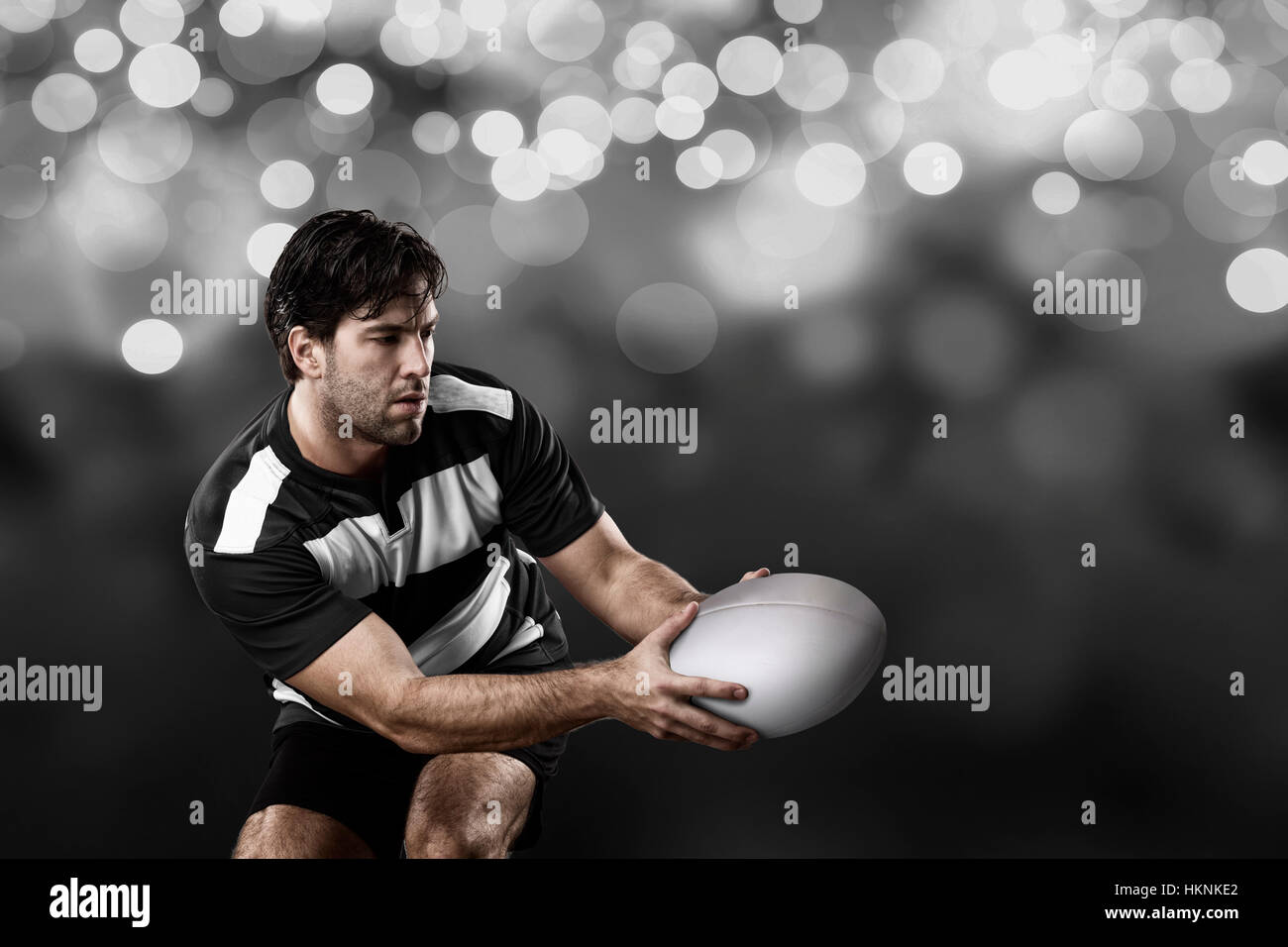 Rugby player in a black uniform on a black lights background Stock ...