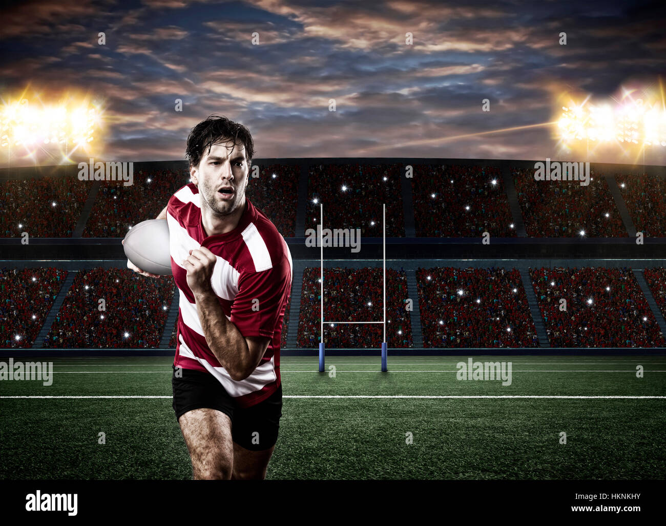 Rugby player in a red uniform running on a stadium Stock Photo - Alamy