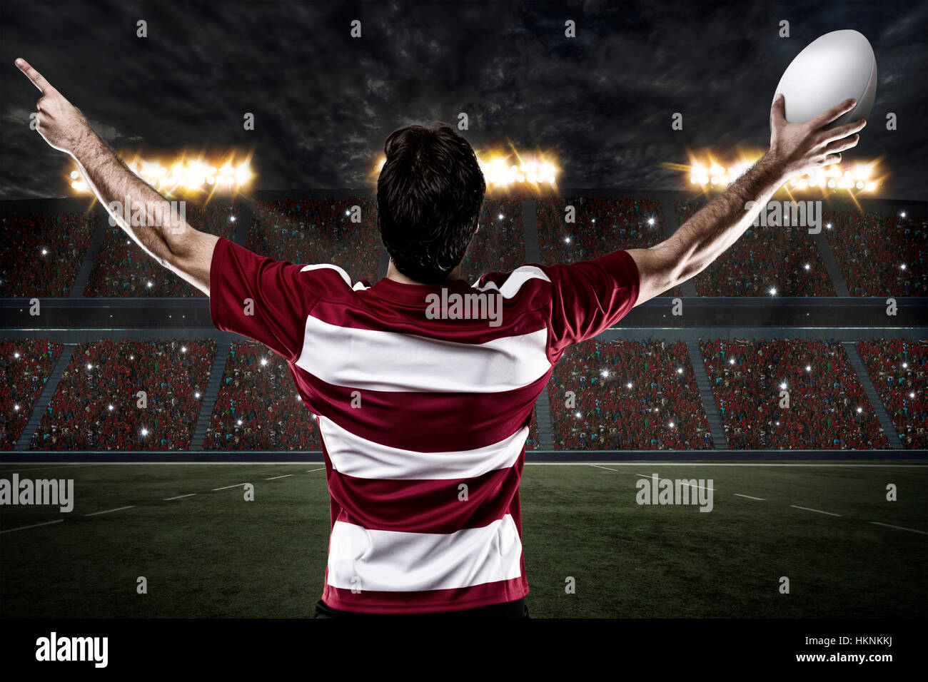 Rugby player in a red uniform celebrating on a stadium Stock Photo - Alamy