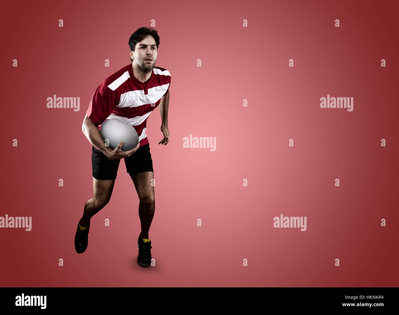 Rugby player in a red uniform running on a red background Stock Photo ...