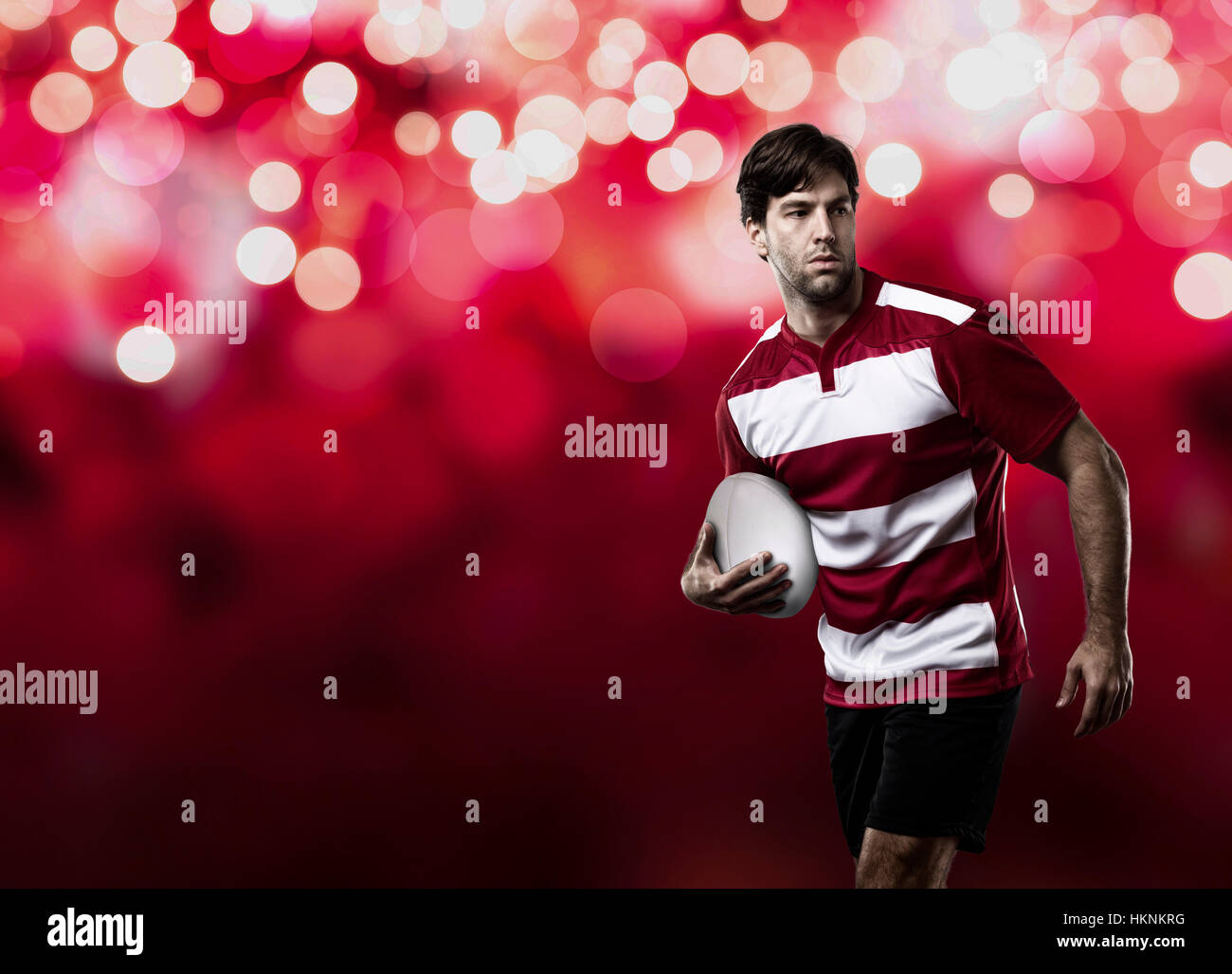 Rugby player in a red uniform on a red lights background Stock Photo ...