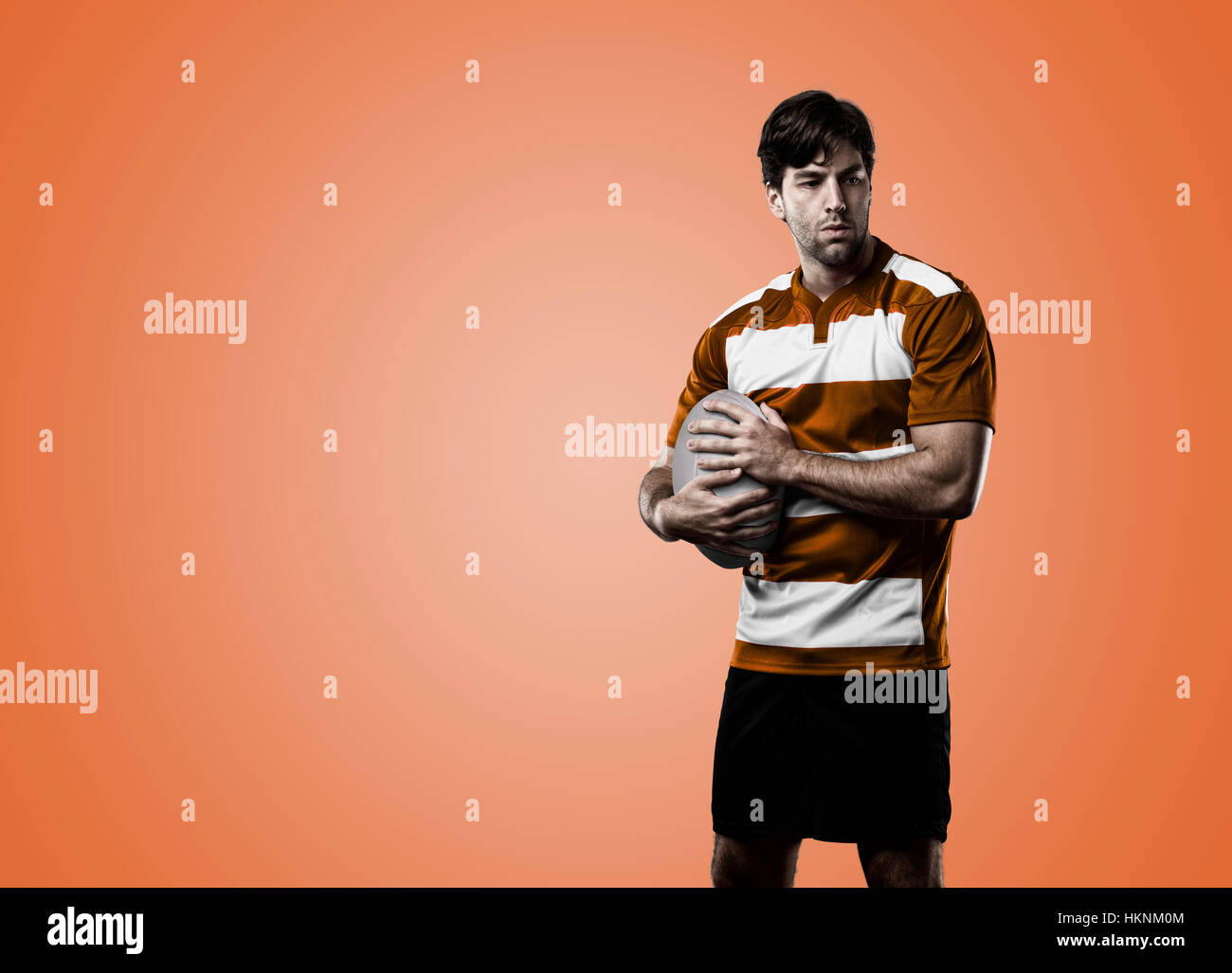 Rugby player in a orange uniform on a orange background Stock Photo - Alamy