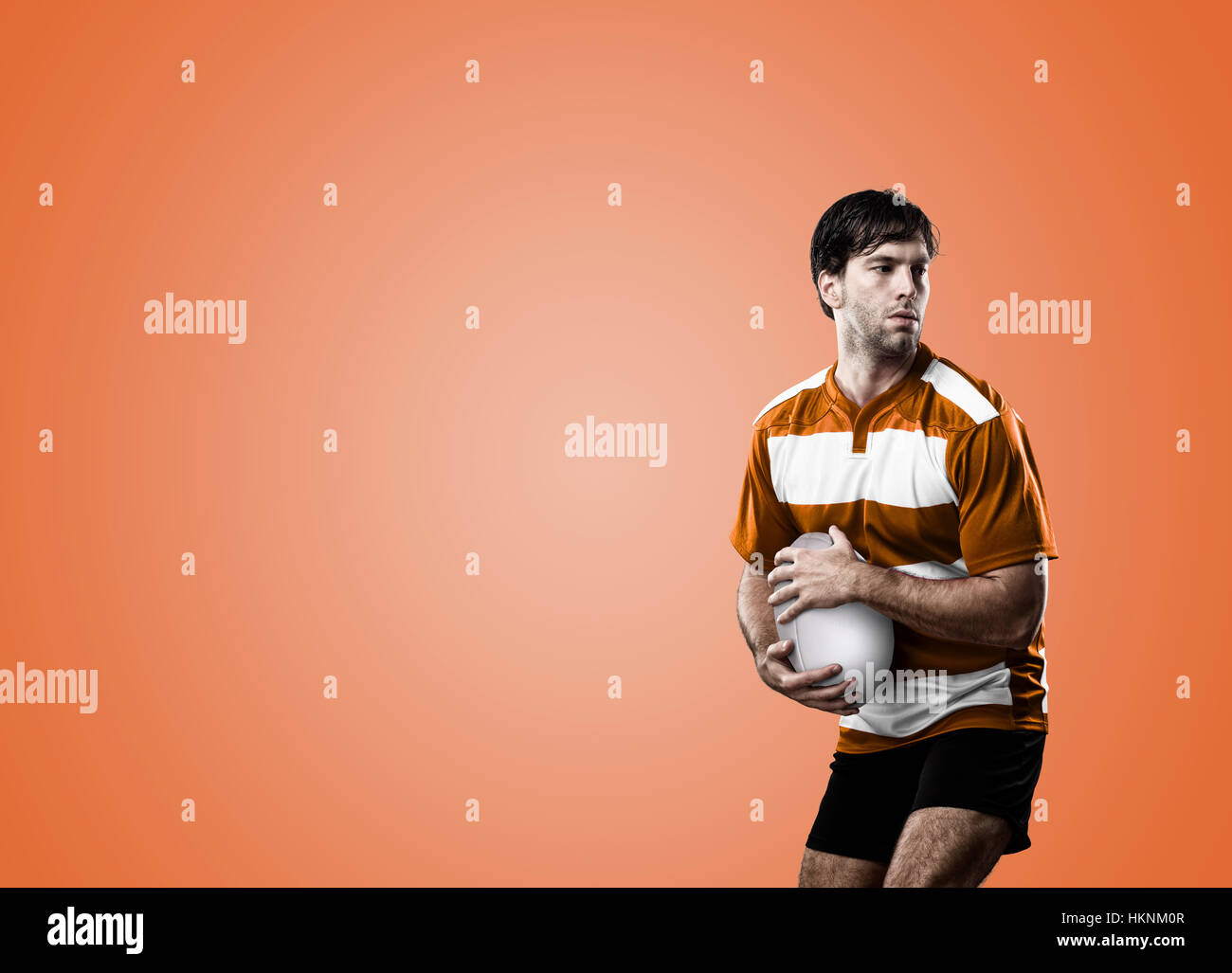 Rugby player in a orange uniform on a orange background Stock Photo - Alamy