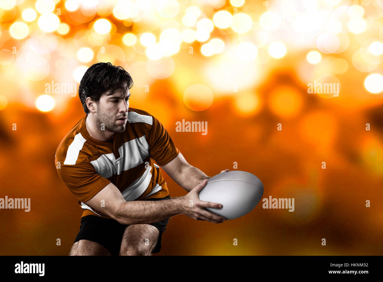 Rugby player in a orange uniform on a orange lights background Stock ...