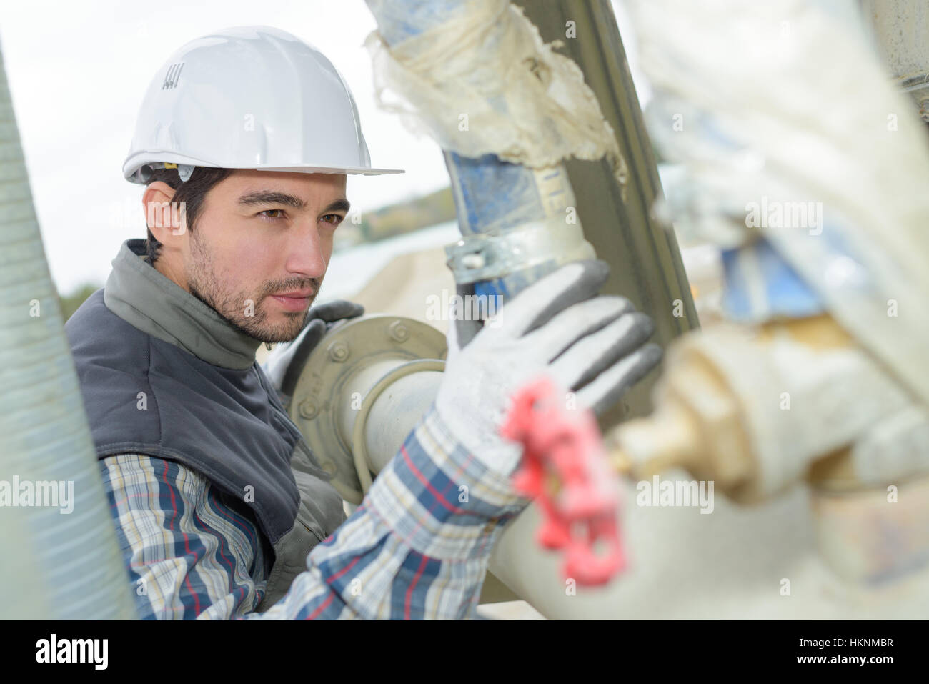 Man inspecting industrial pipework Stock Photo - Alamy