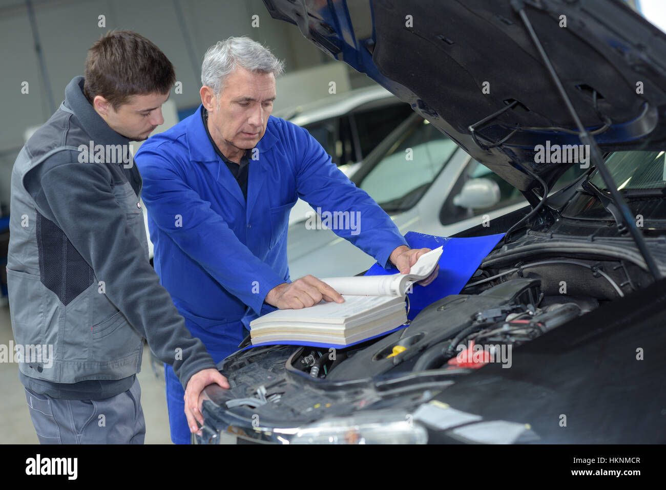 auto mechanic teacher and trainee performing tests at mechanic school ...