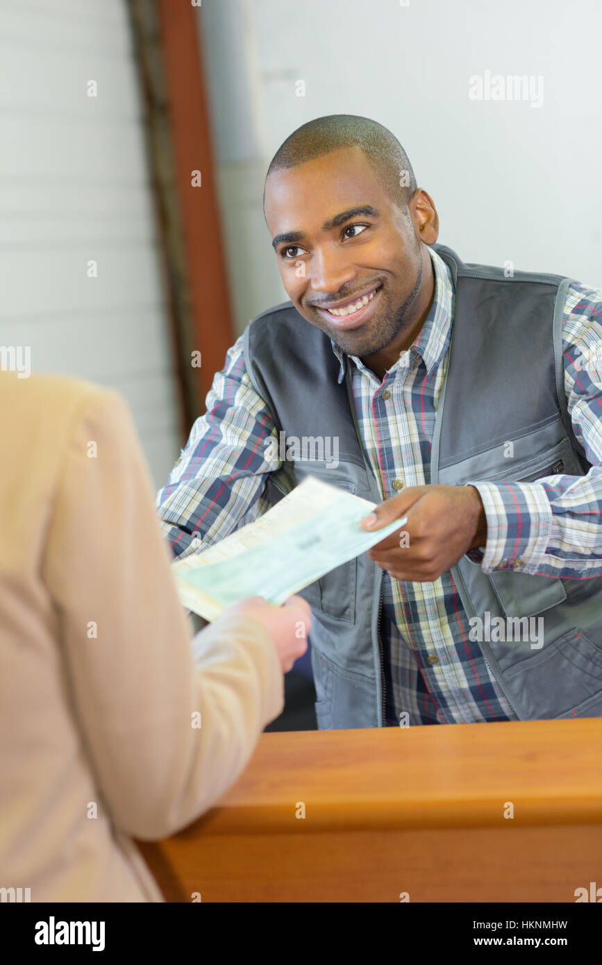 Man passing paperwork to customer Stock Photo - Alamy