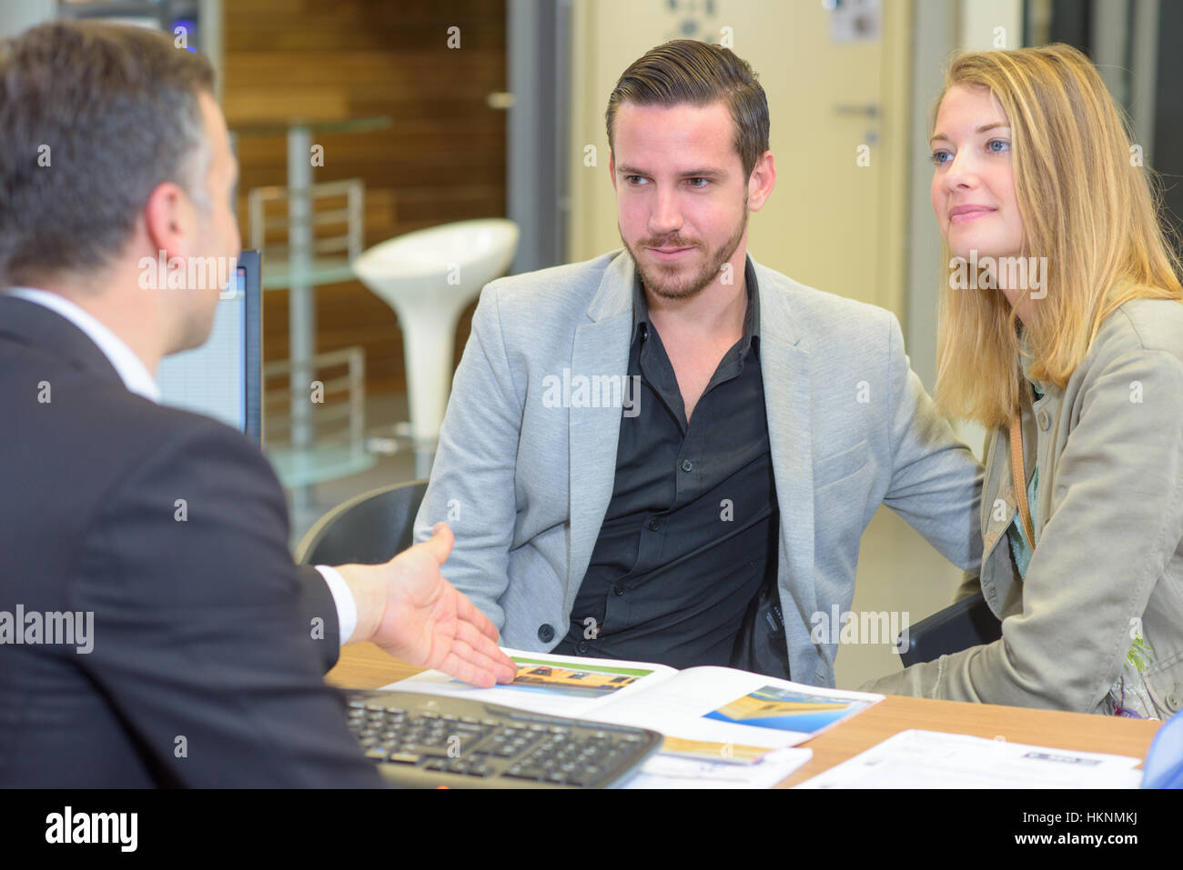 Couple talking with a salesman Stock Photo - Alamy