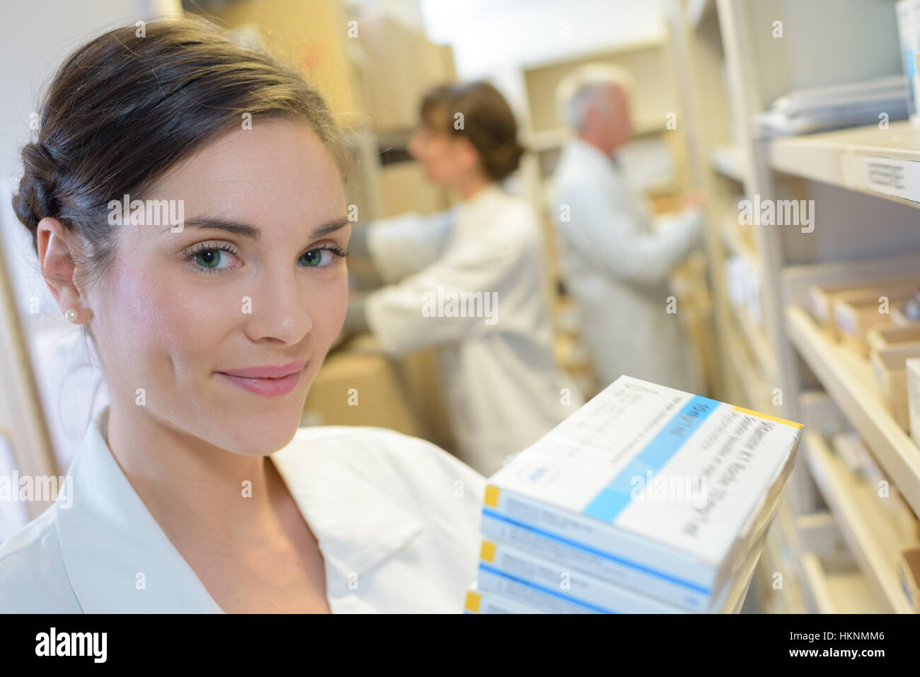 young and pretty pharmacist ordering drugs in different shelfs Stock ...