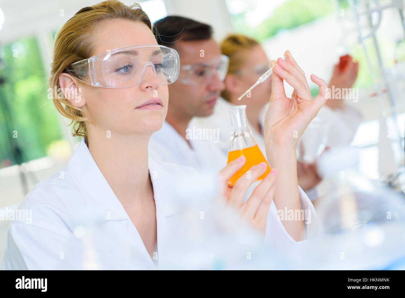 Lab technician holding pipette and erlenmeyer flask Stock Photo - Alamy