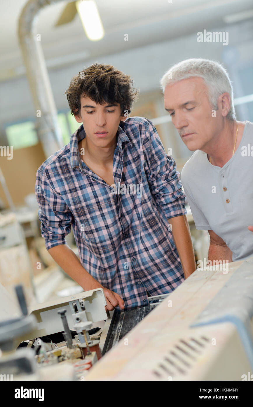 men looking at machine Stock Photo - Alamy