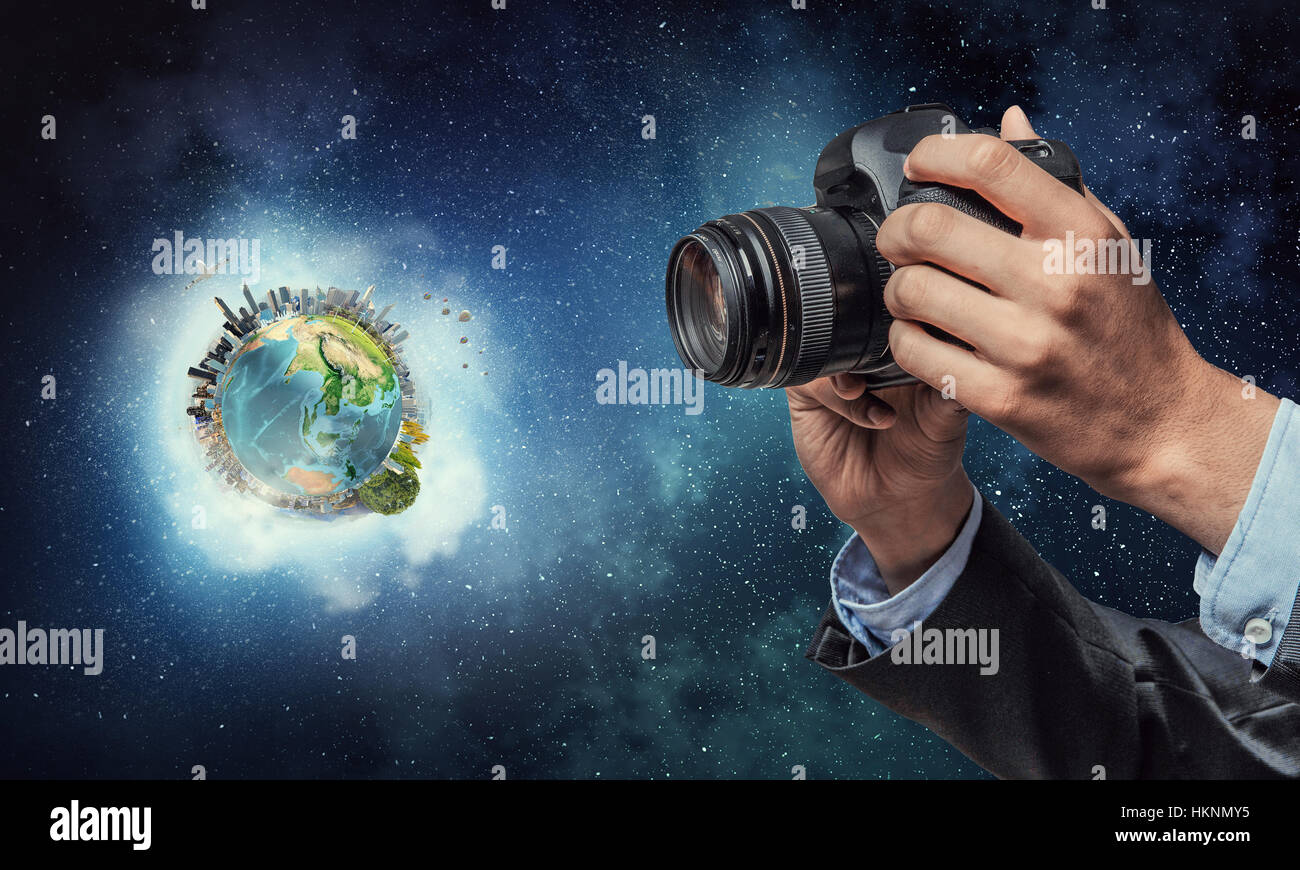 Close of man holding camera and taking photos of Earth planet. Elements ...