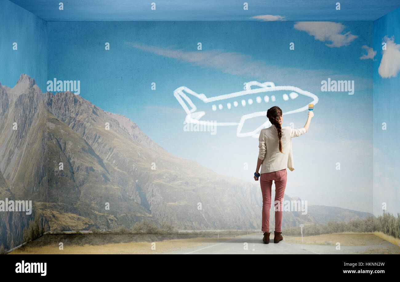 Young woman traveller drawing airplane on wall Stock Photo - Alamy