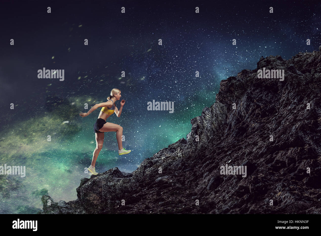 Young woman athlete running fast up the rock mountain Stock Photo - Alamy