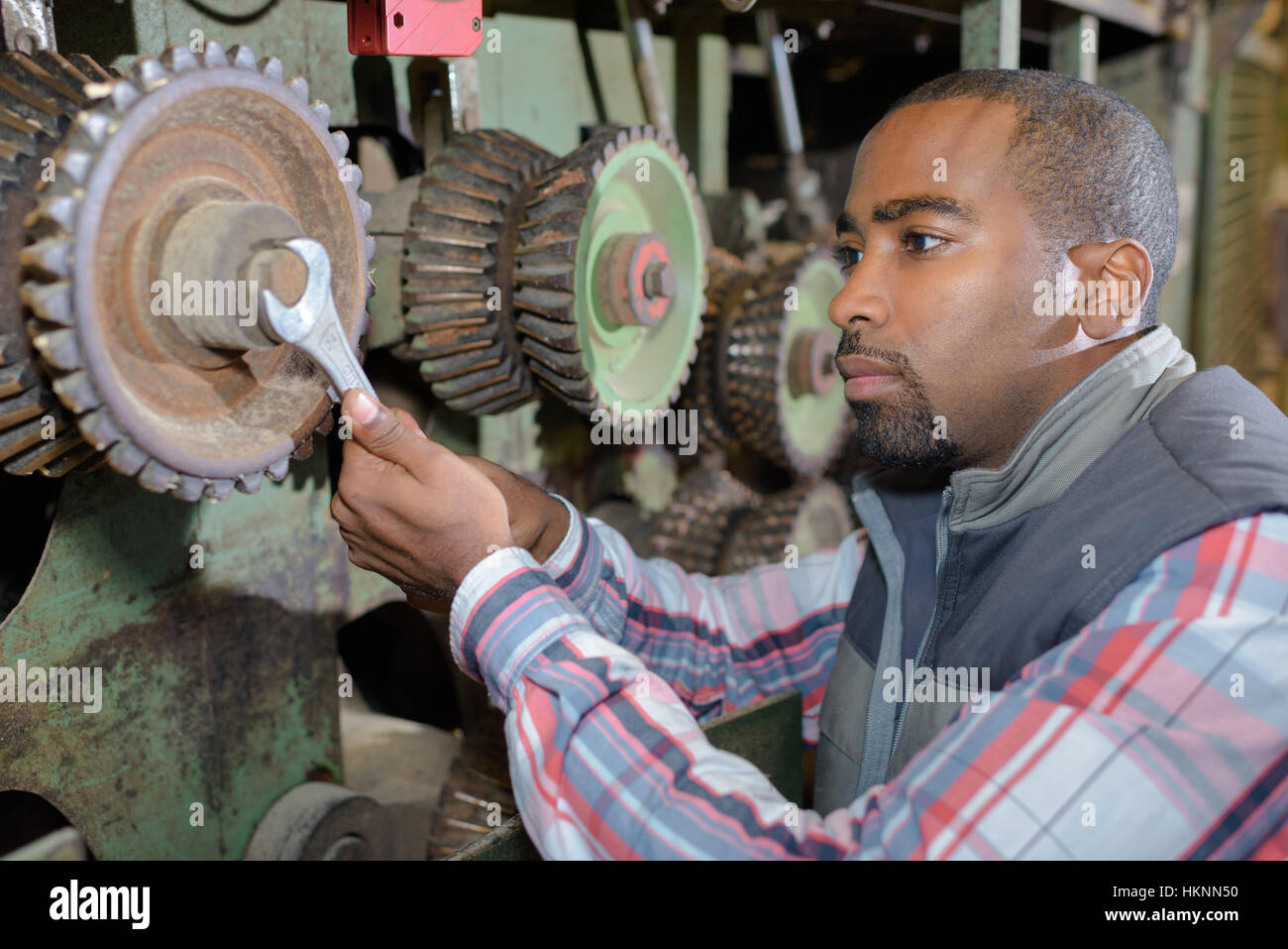 Man tightening cog with spanner Stock Photo - Alamy