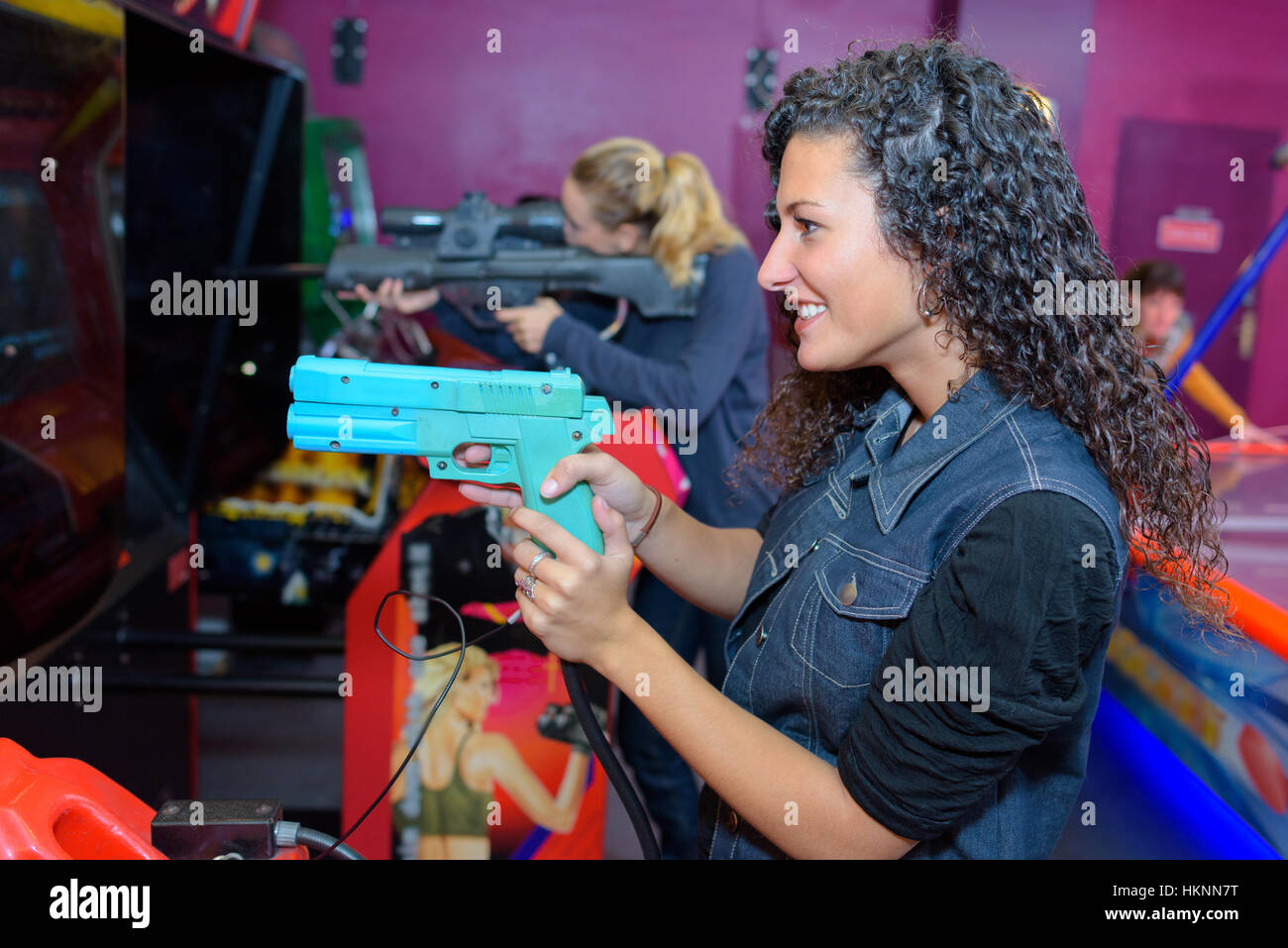 Women holding rifle of arcade game Stock Photo - Alamy
