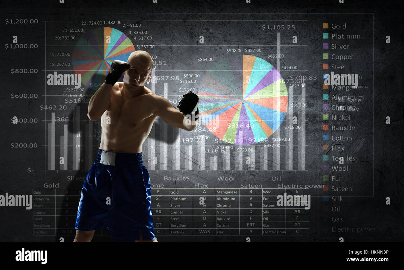 Young determined man boxing against graphs background. Mixed media ...