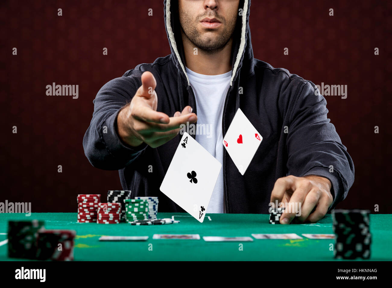 Poker player, on a red background, throwing two ace cards Stock Photo ...