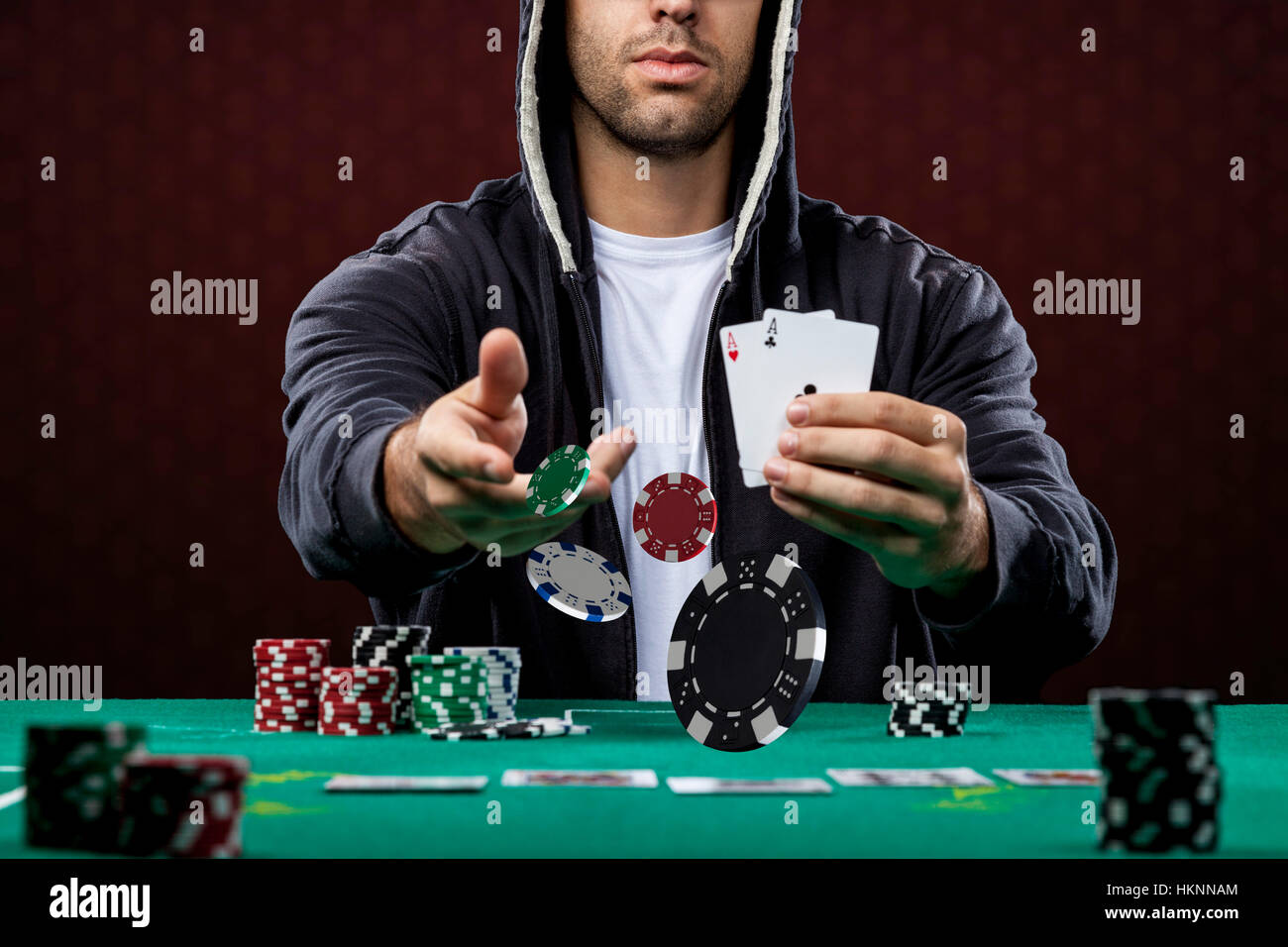 Poker player, on a red background, throwing poker chips Stock Photo - Alamy